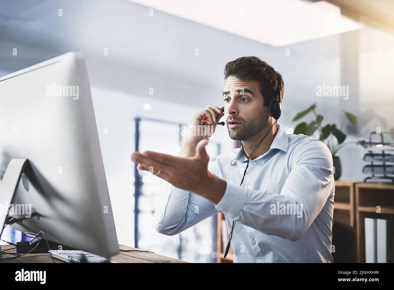 Dealing with a difficult client. a young call centre agent looking ...