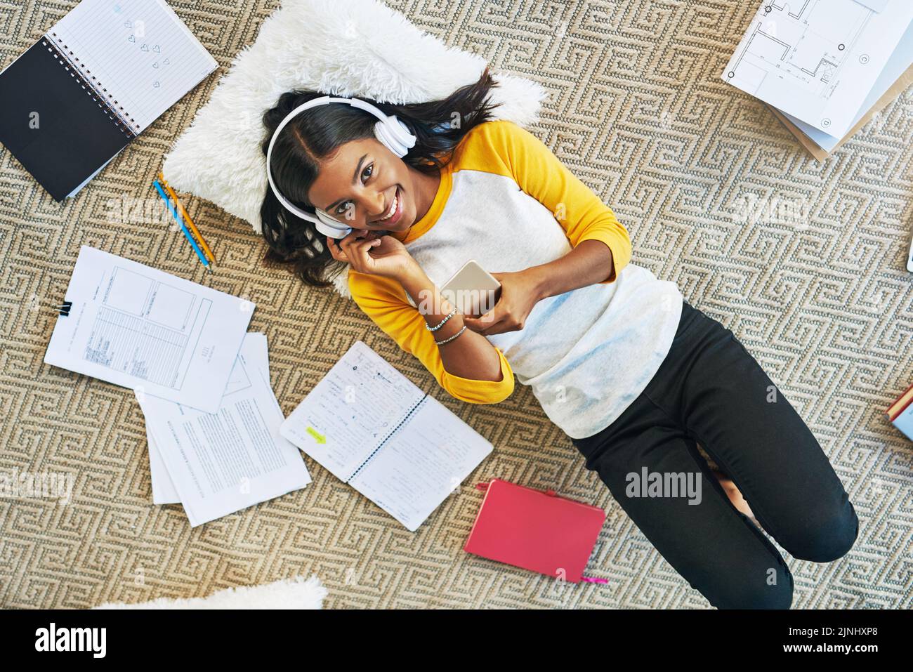 Music helps me study. High angle shot of a young female student ...