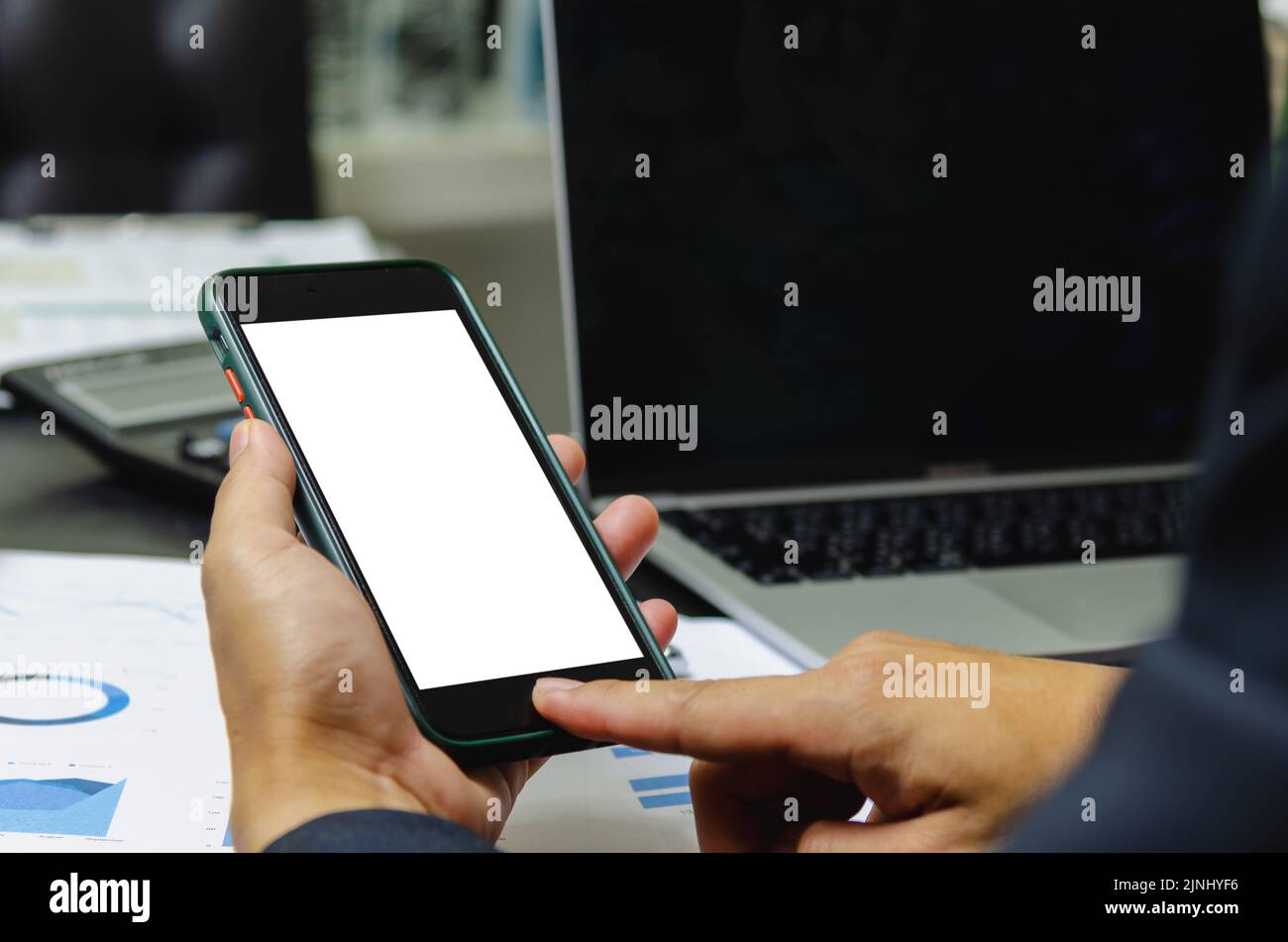 Man holding mobile smartphone mock up blank white screen and computer ...