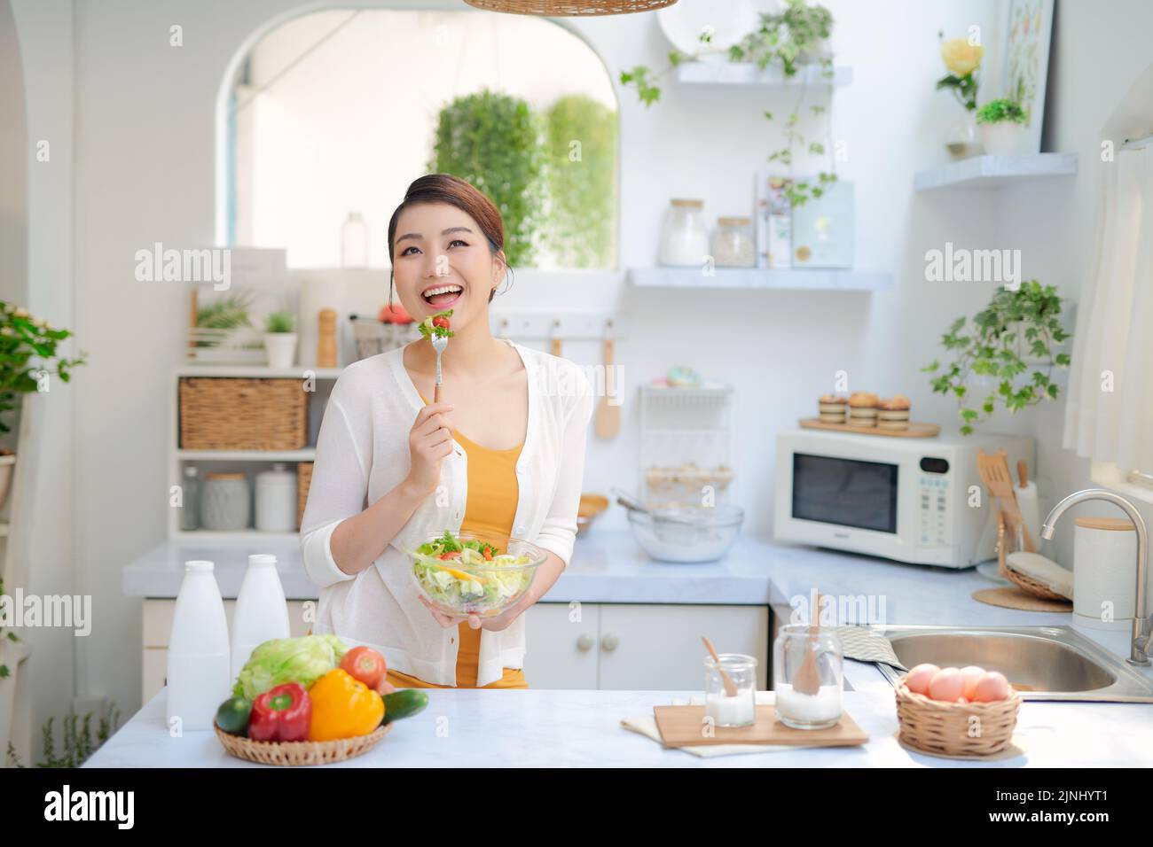 Close up portrait of cute girl eating salad on kitchen Stock Photo - Alamy