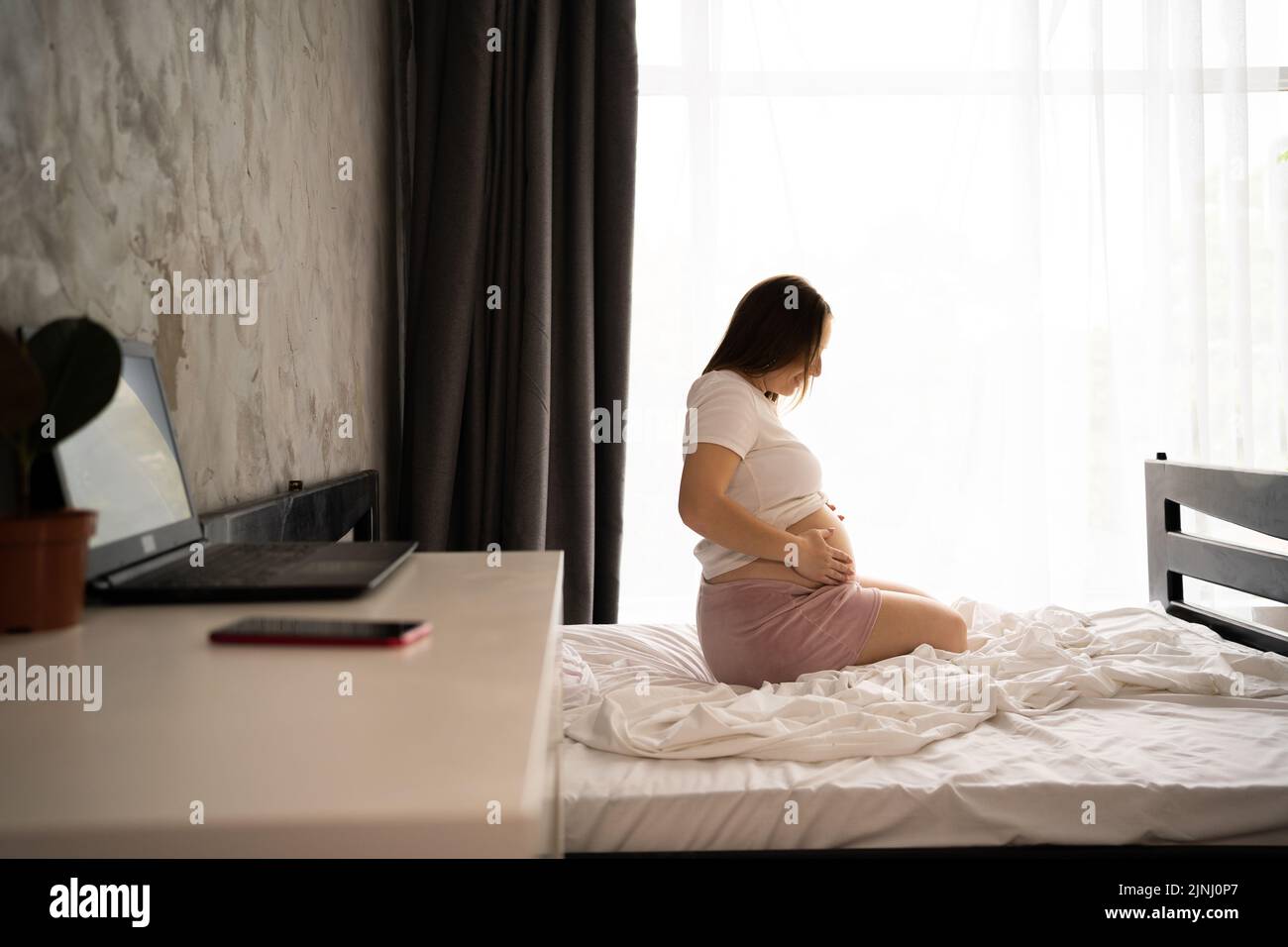 Attractive Pregnant Woman Sitting In Bed And Holding Her Belly Bedroom 4345