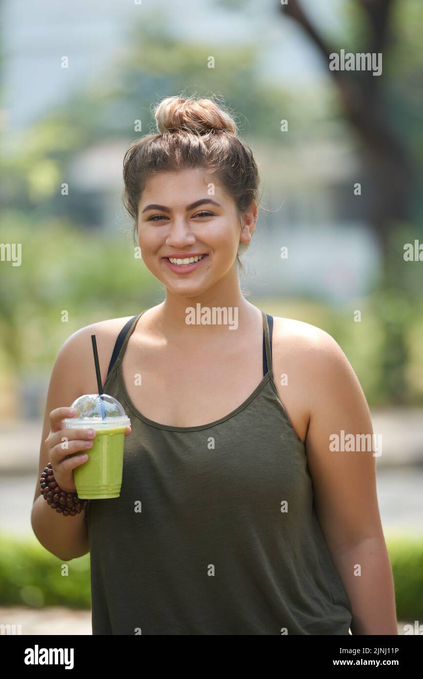 Waist Up Portrait Of Attractive Young Woman Looking At Camera With Wide Smile And Holding