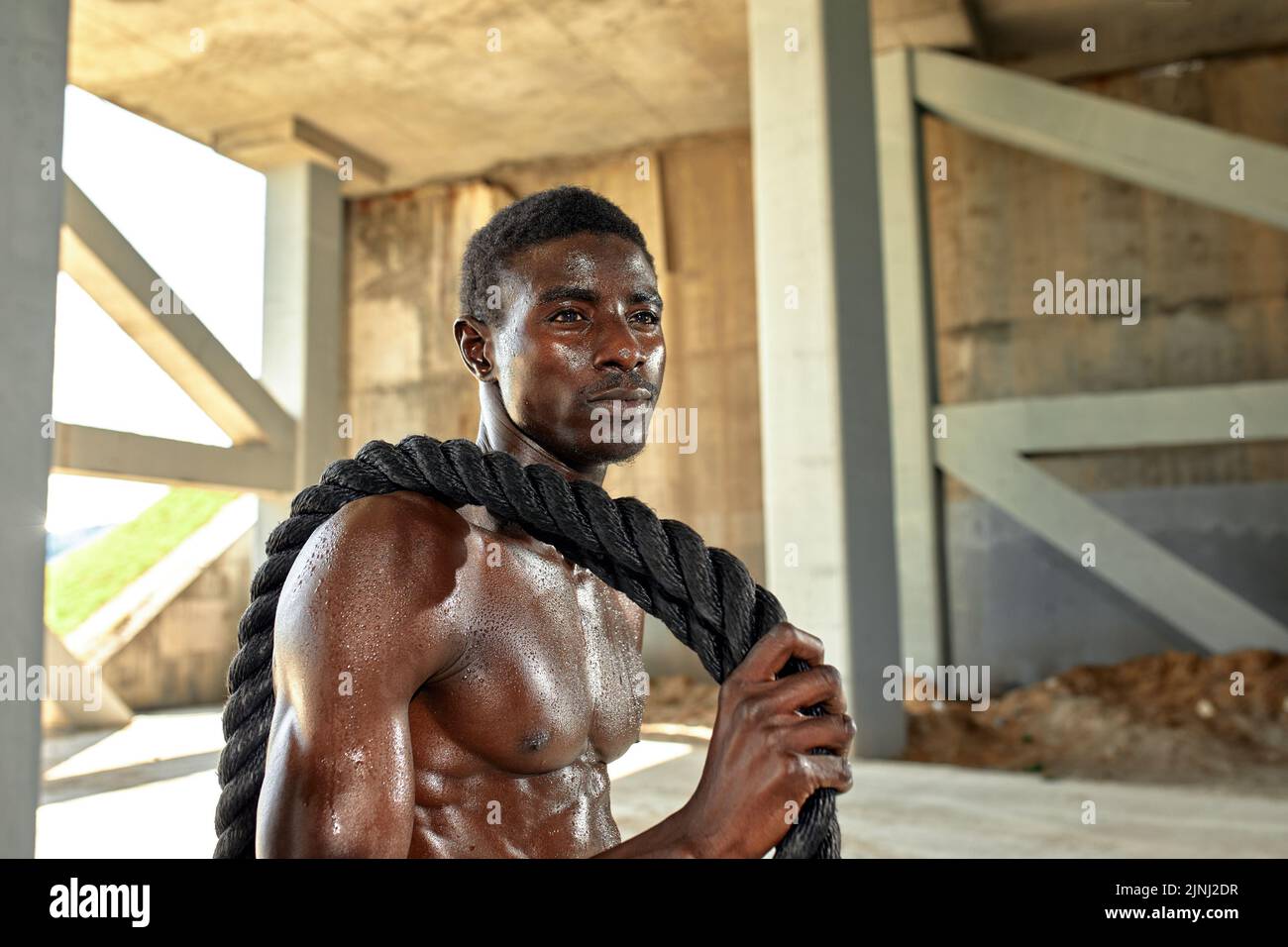 Rope workout. Sport man doing battle ropes exercise outdoor. Black male ...