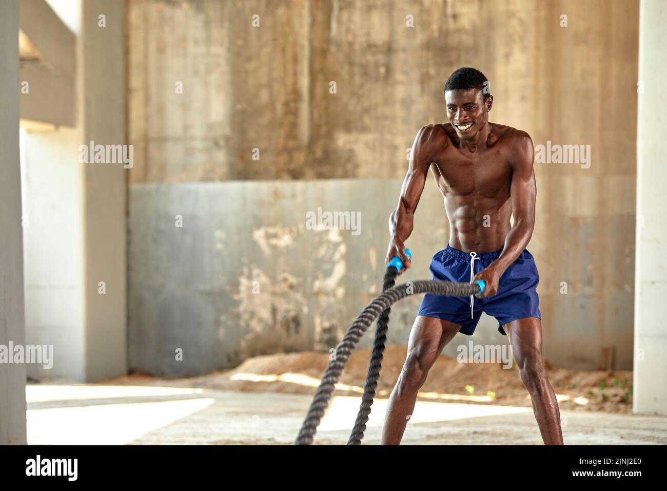 Sportsman doing heavy rope training hi-res stock photography and images ...