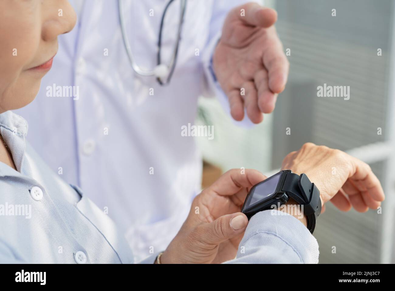 Close-up shot of unrecognizable patient checking her heart rate with ...