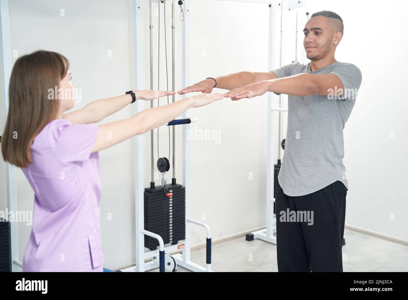 Man doing kinesiotherapy gymnastics with doctor in clinic Stock Photo ...