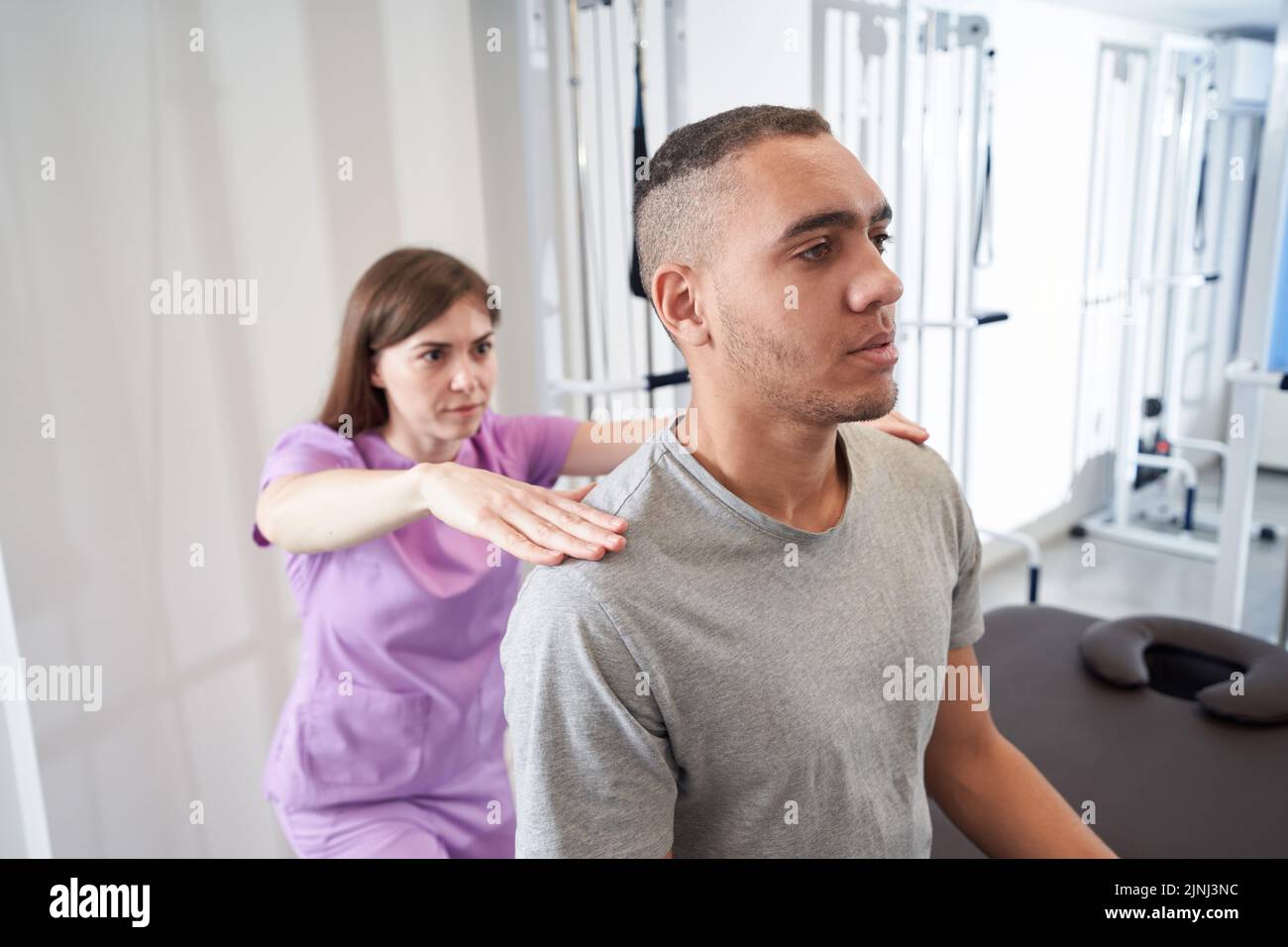Doctor measuring shoulders symmetry of male patient in clinic Stock ...