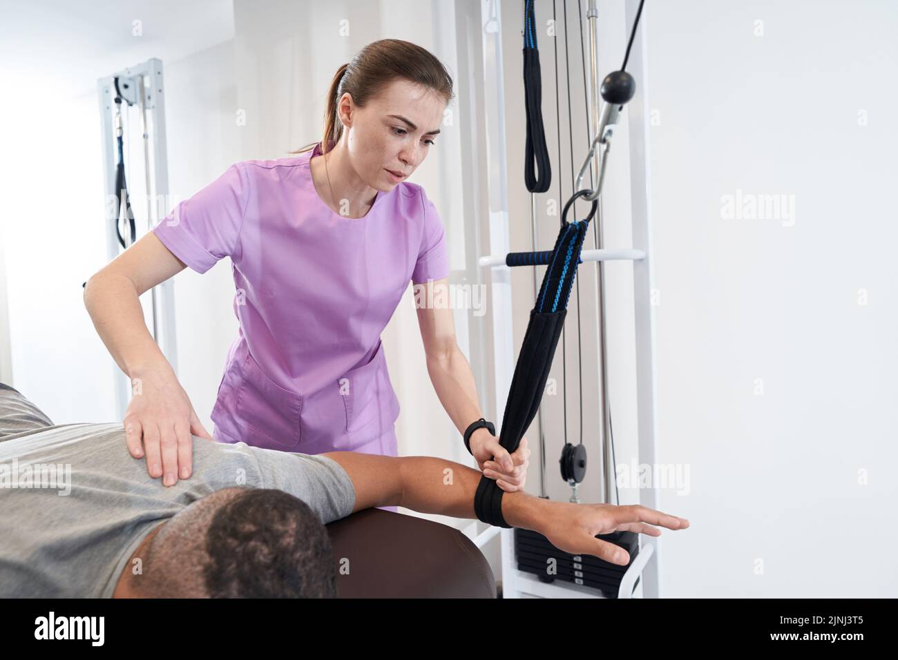 Man doing physiotherapy exercise with doctor in rehabilitation clinic ...