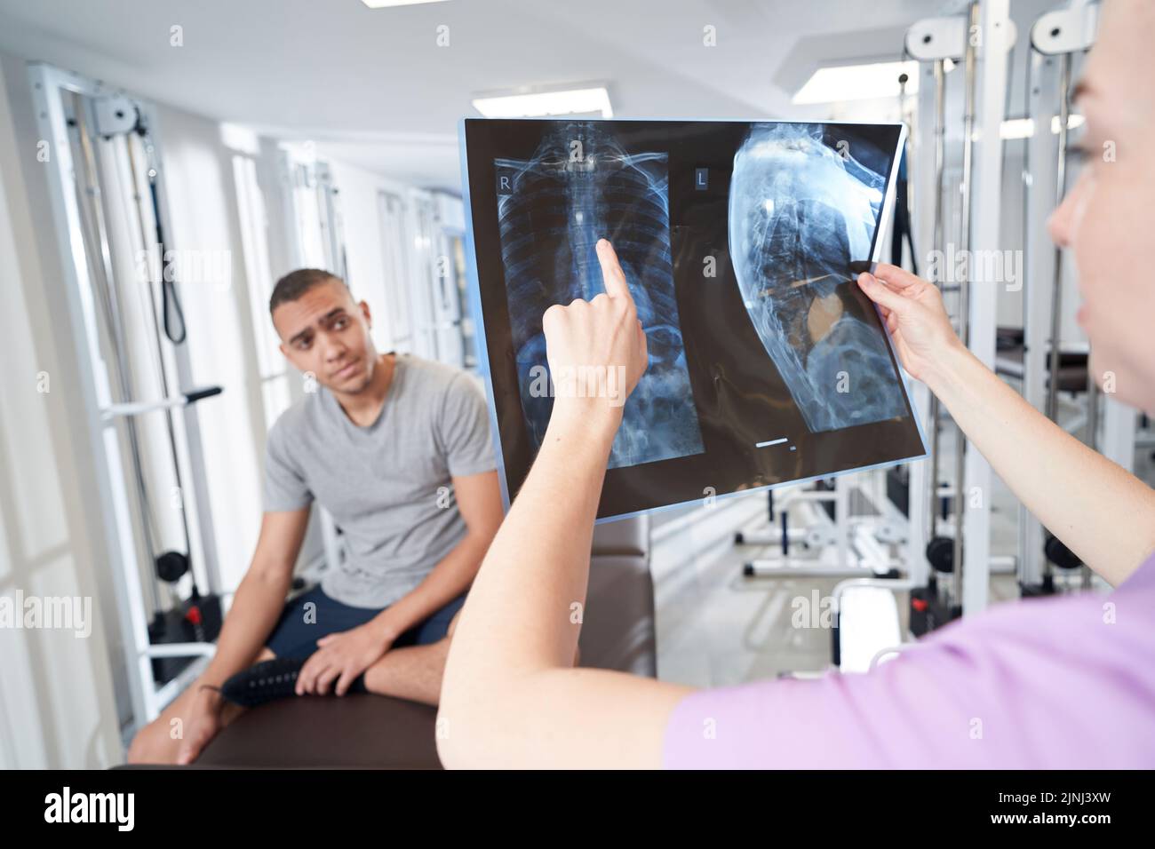 Female doctor showing x-ray scan to man in clinic Stock Photo - Alamy