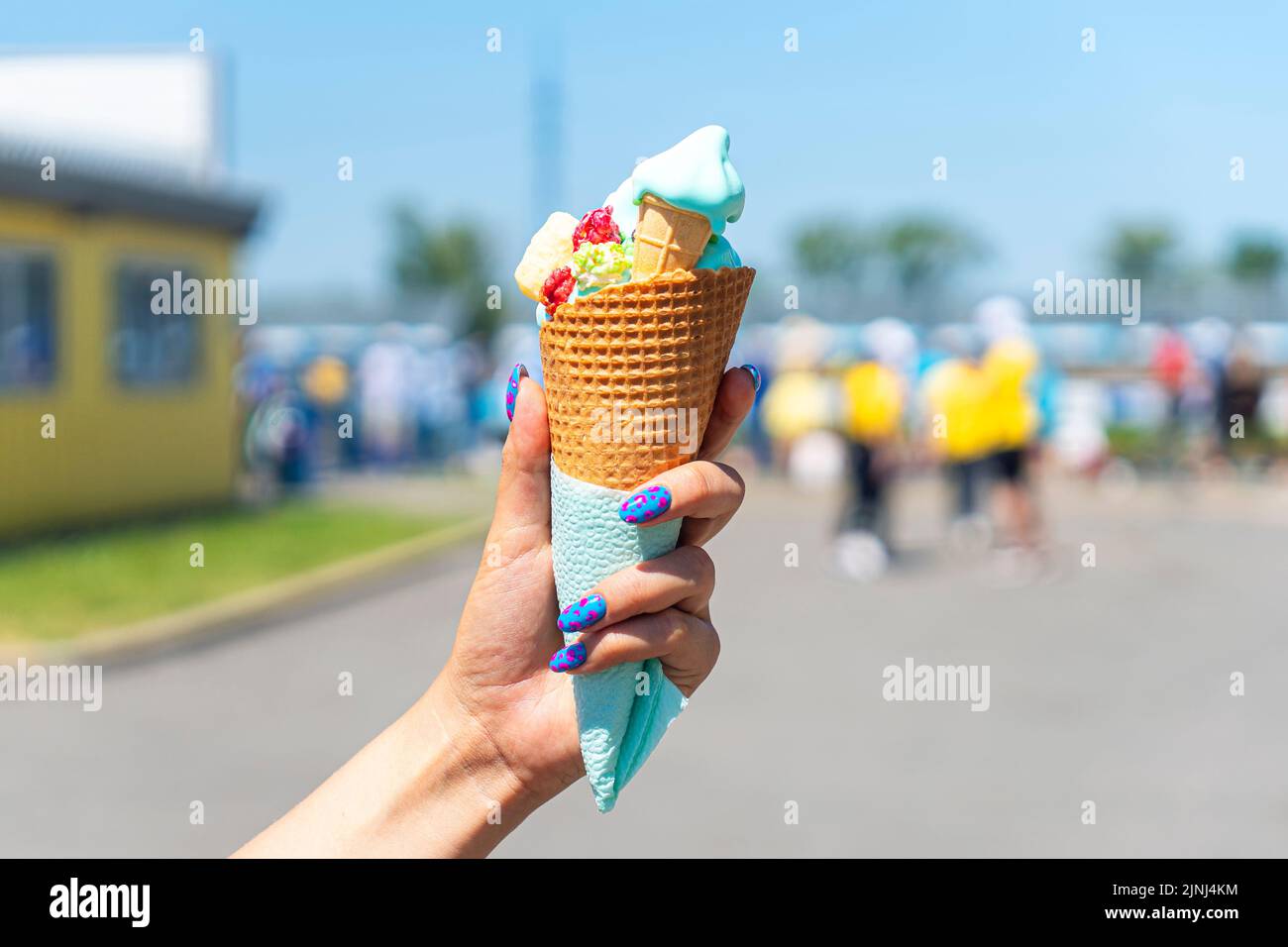 Melted ice cream from the hot summer weather in a woman's hand on the ...
