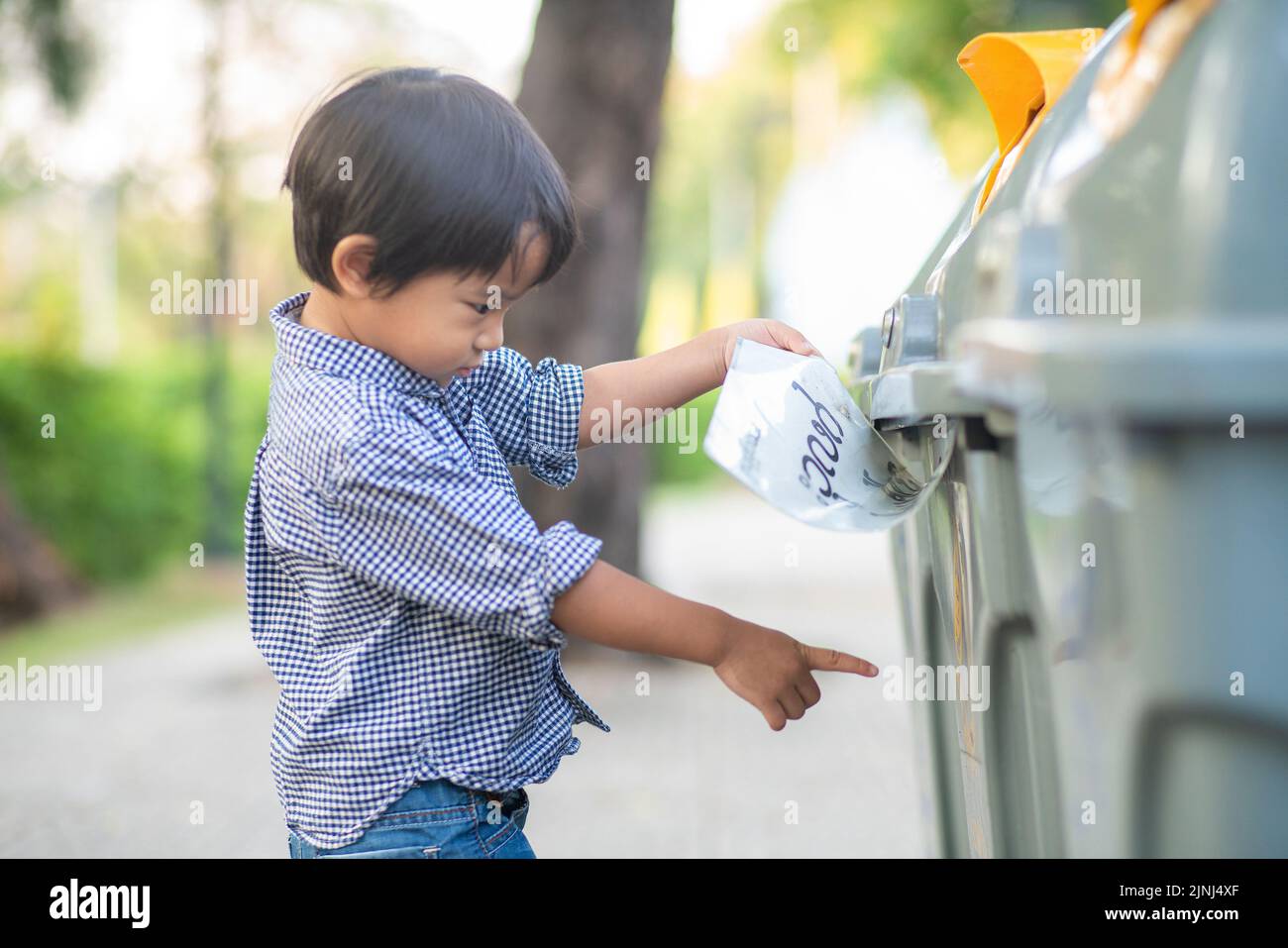 Boy keep litter garbage into bin in city park keep clean concept Stock ...