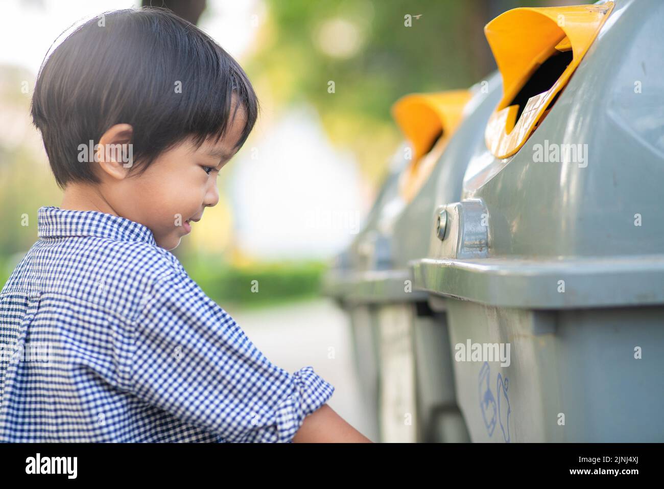Boy keep litter garbage into bin in city park keep clean concept Stock ...