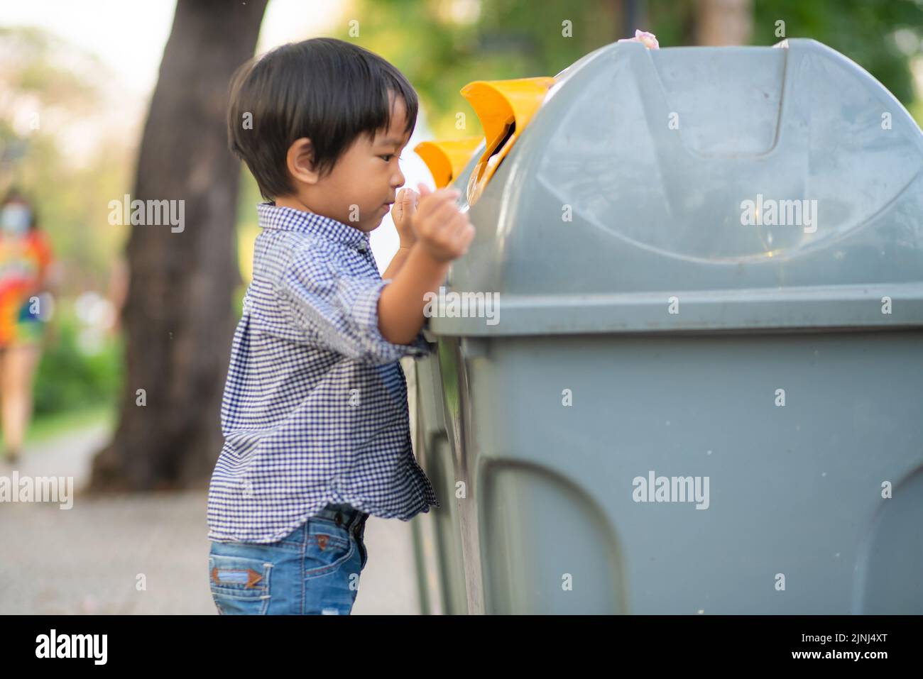 Boy keep litter garbage into bin in city park keep clean concept Stock ...