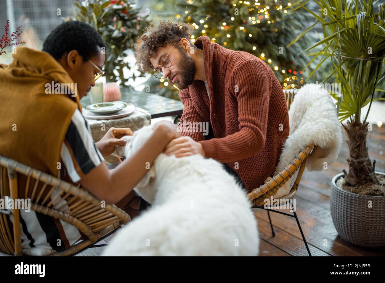 Two multiracial male friends having close conversation, sitting by a ...