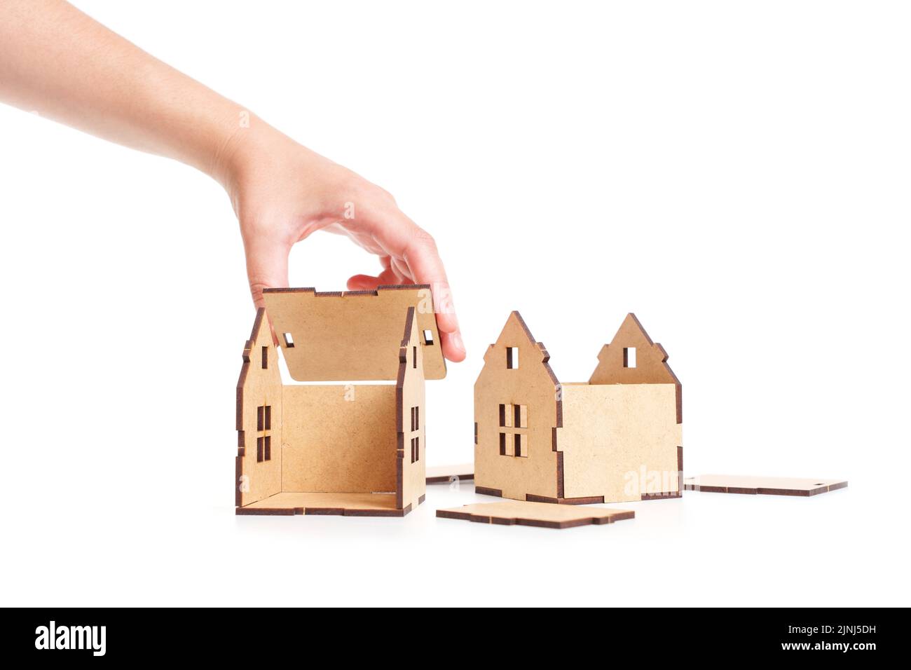 Assembling wooden house models isolated on white Stock Photo - Alamy