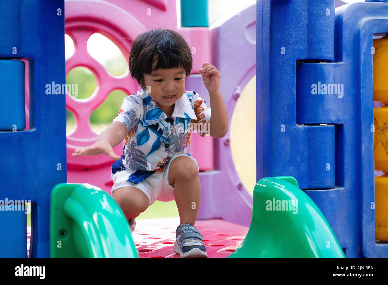 Little asian boy playing in colorful playground outdoor public park ...