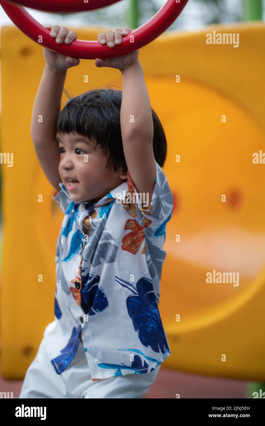 Little asian boy playing in colorful playground outdoor public park ...