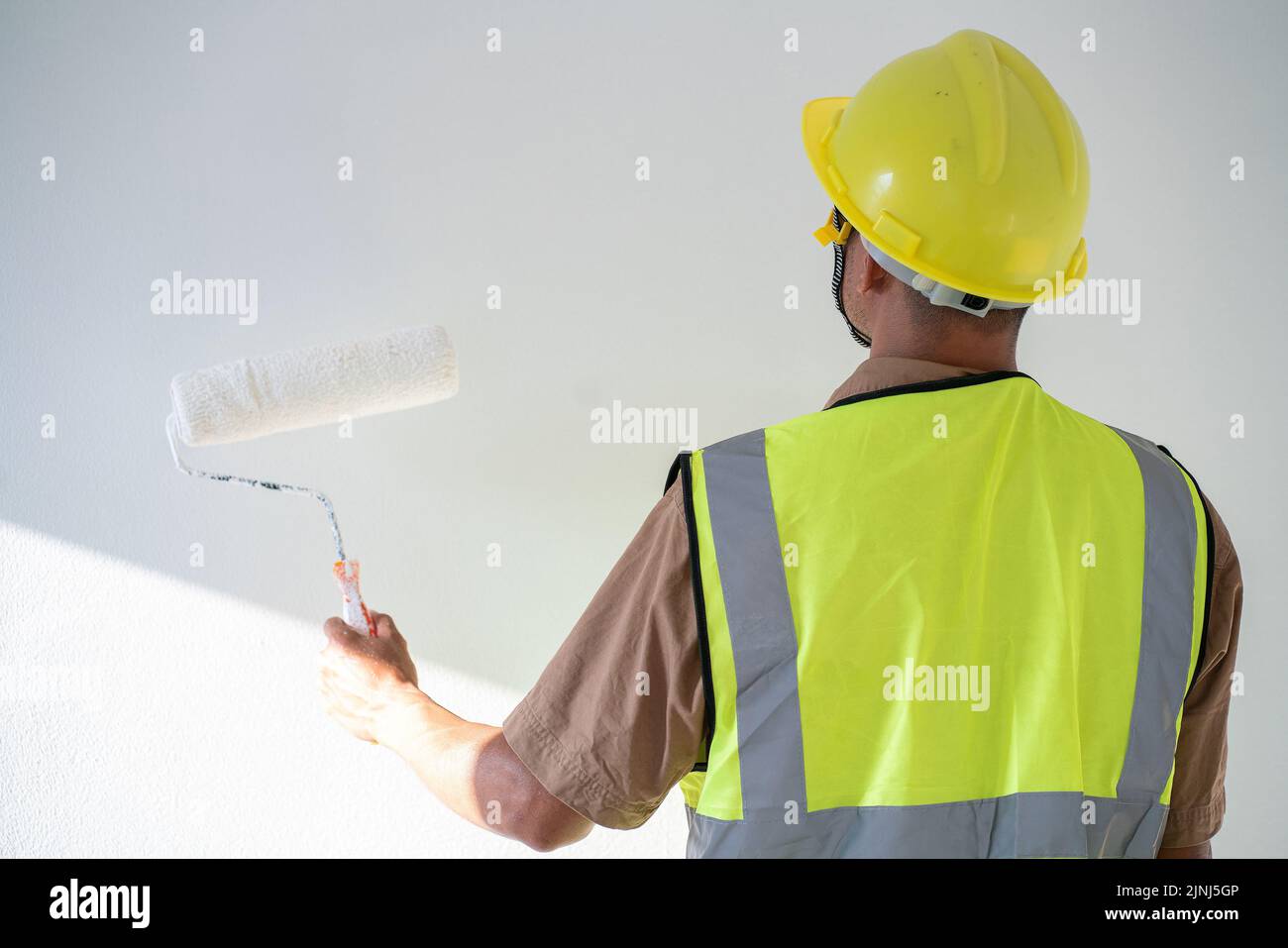 Men paint indoor color with roller paint on white background Stock ...