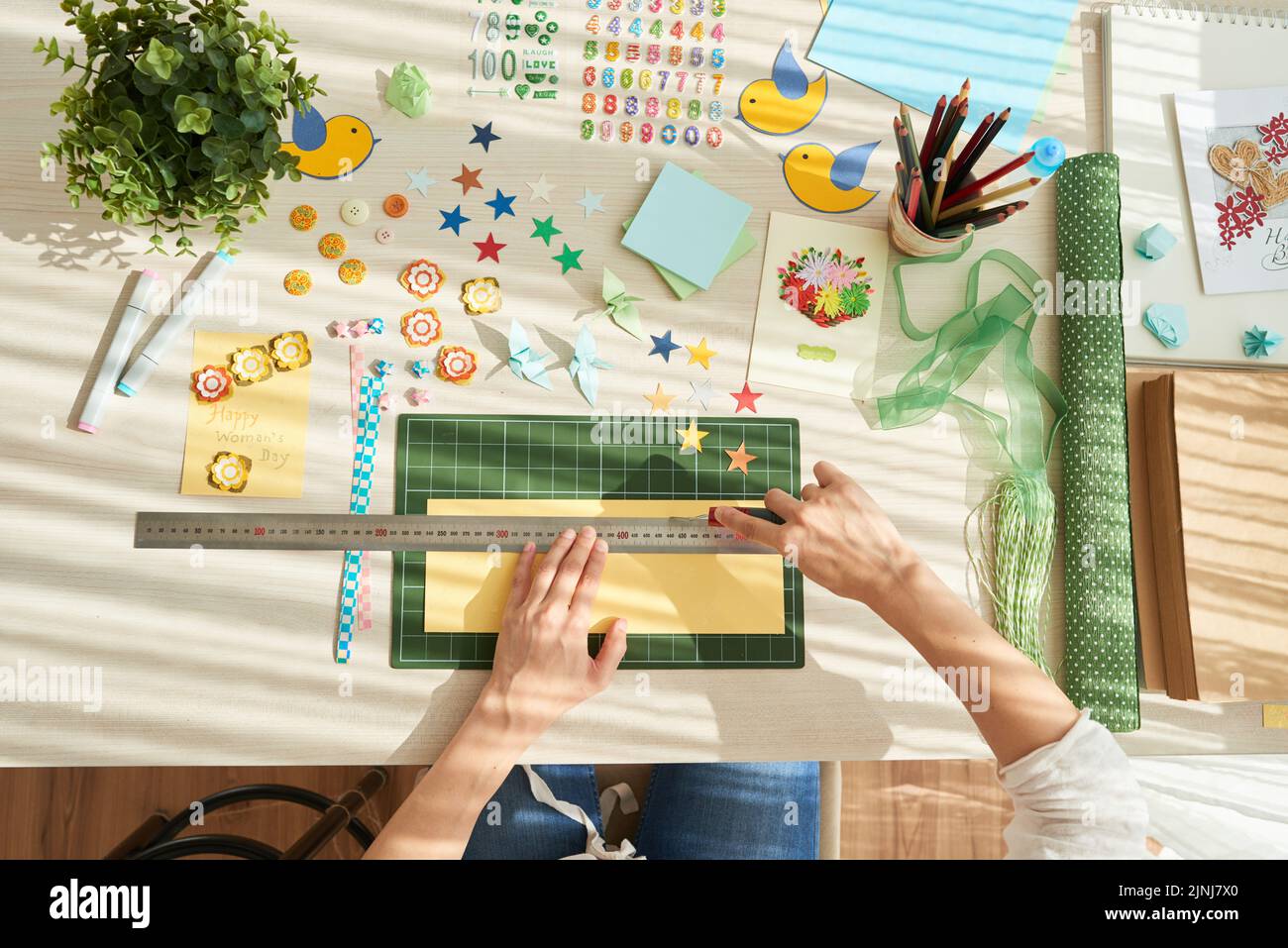 Directly above view of unrecognizable woman using ruler and cutter ...