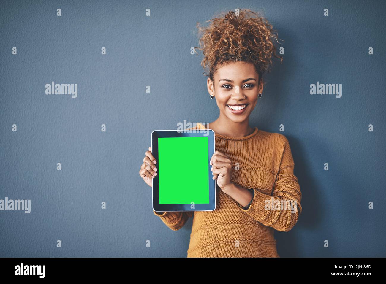 African female holding green screen tablet copyspace. Cute, attractive ...