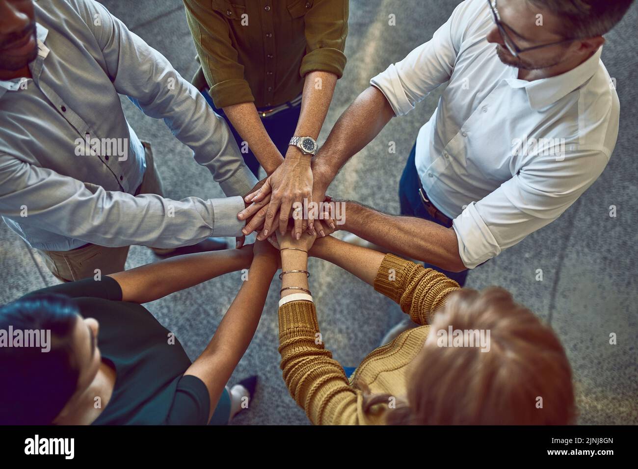 Successful, celebrating and winning colleagues stack hands in unity ...