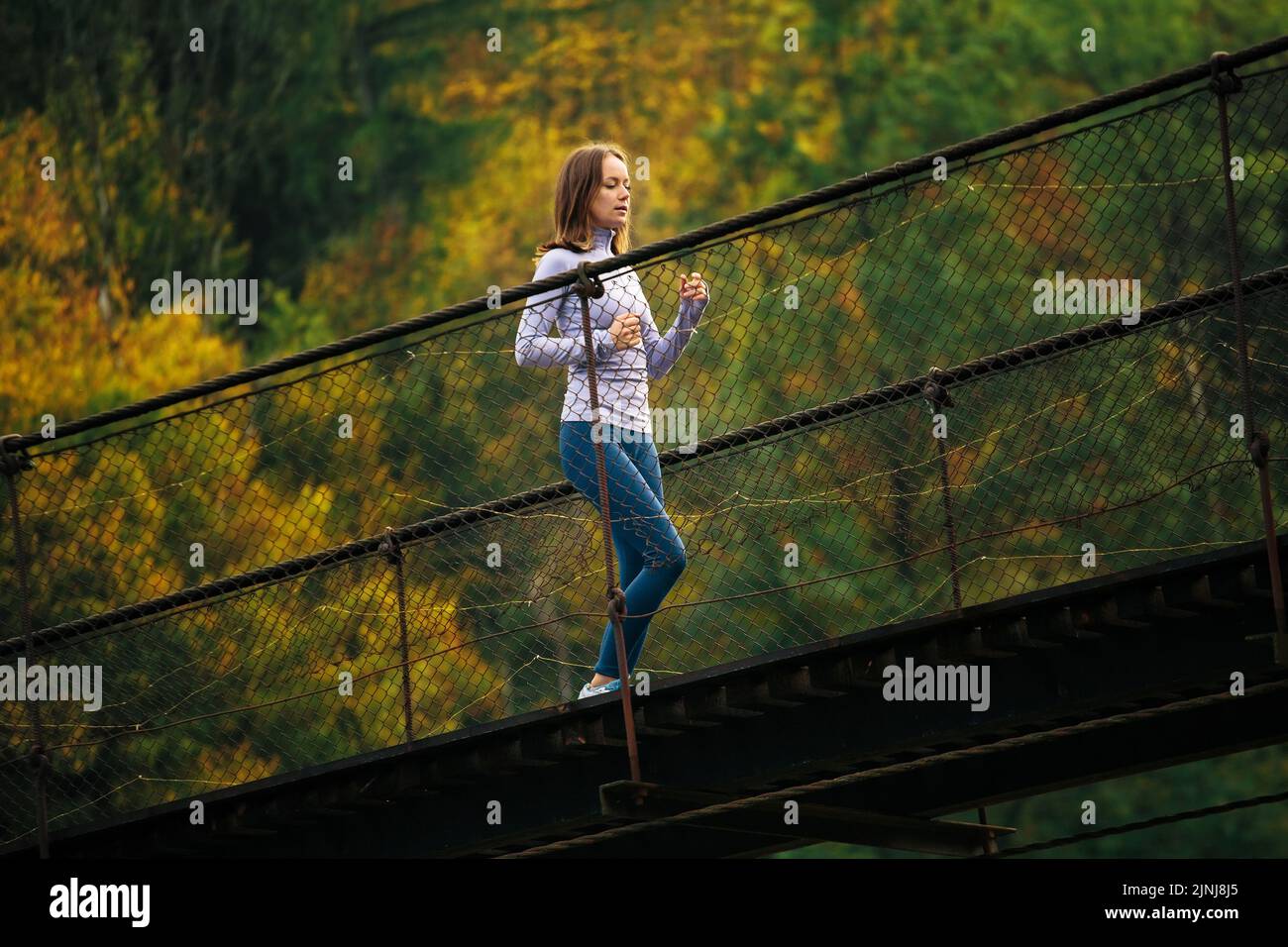 View from below of a young sports woman performing a morning jog on a ...