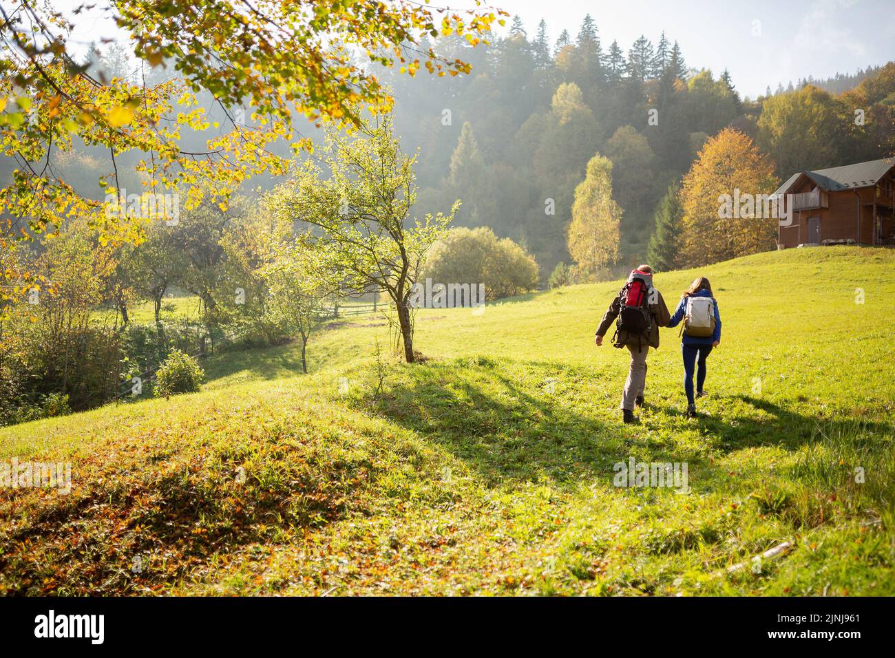 Active tourism. Rear view of a young couple of travelers who lead an ...