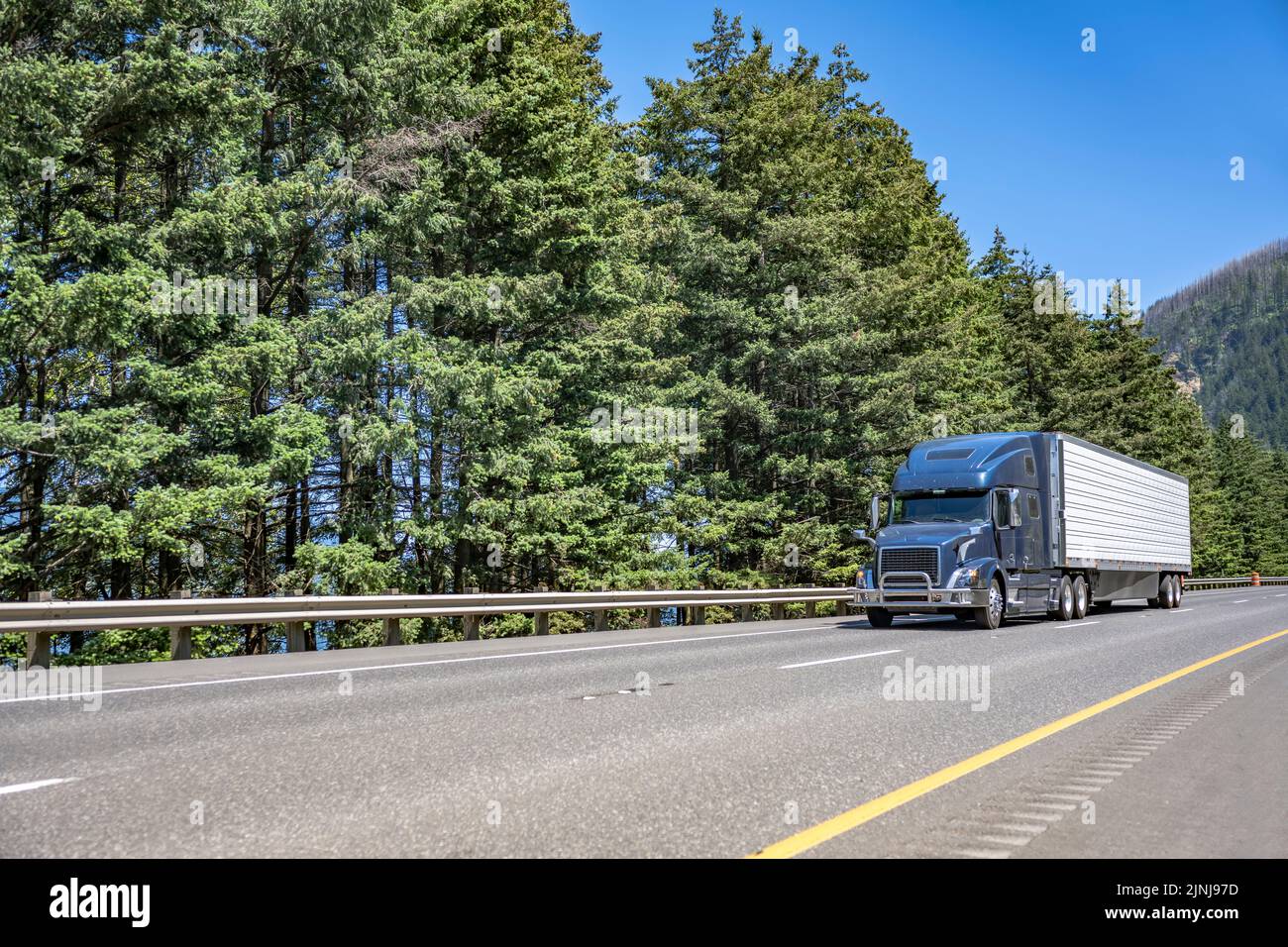 Dark gray industrial big rig semi truck with high roof cab transporting ...