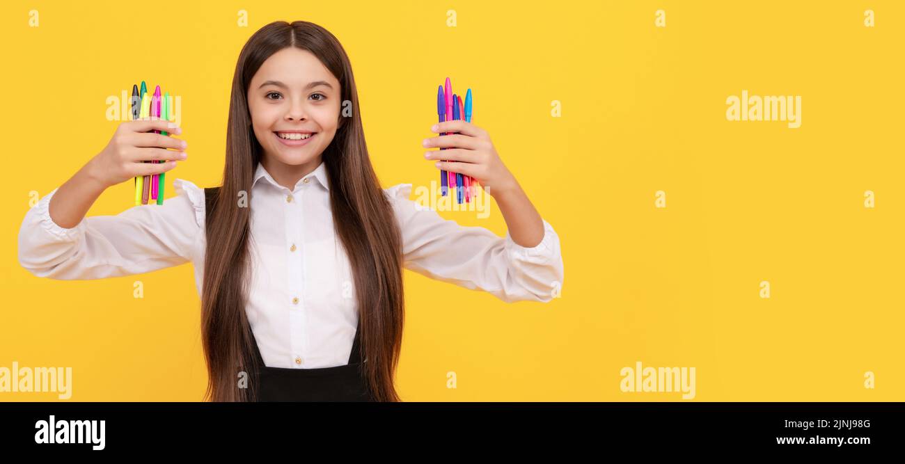 Happy school girl hold felt-tip pens yellow background. Portrait of ...