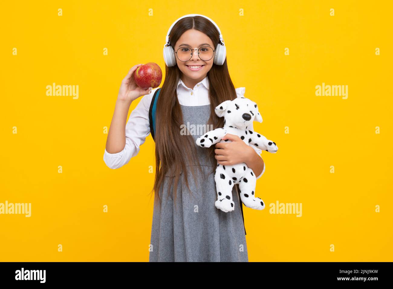 School girl hold toy. School children with favorite toys on yellow ...