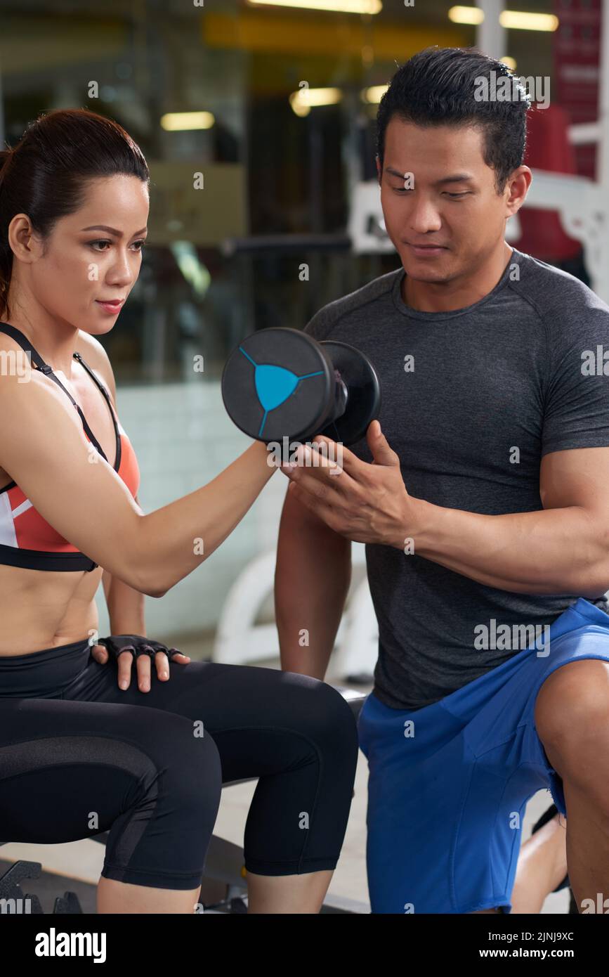 Asian fitness traner explaining how to do exercise with dumbbell Stock ...