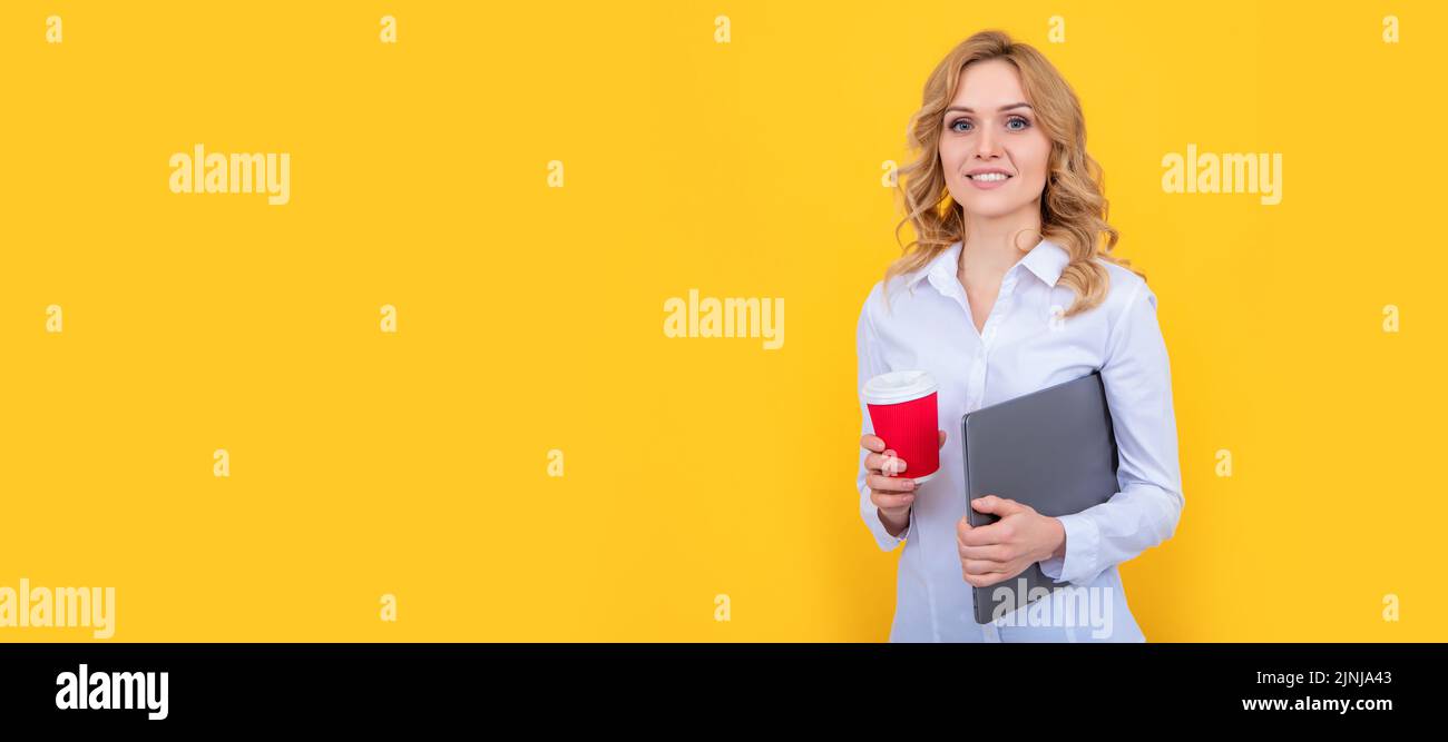 positive blonde woman with coffee cup and computer on yellow background ...