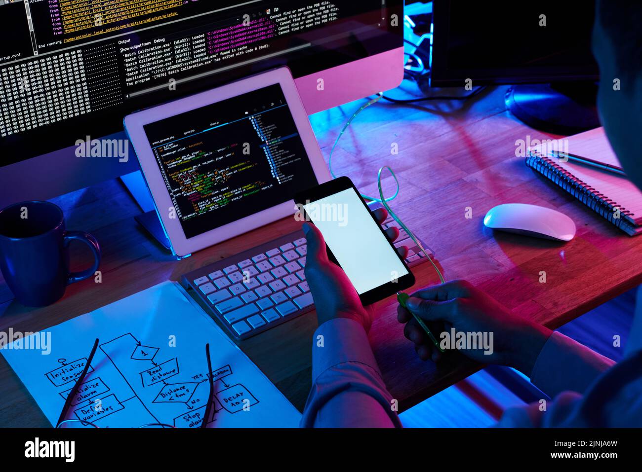 Unrecognizable coder using modern smartphone while sitting at office ...