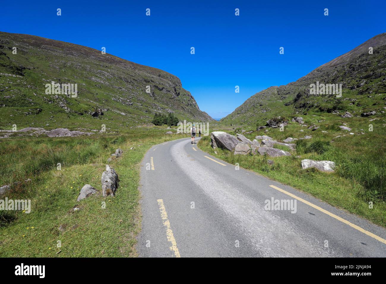 People trekking at The Gap of Dunloe, a narrow mountain pass running ...