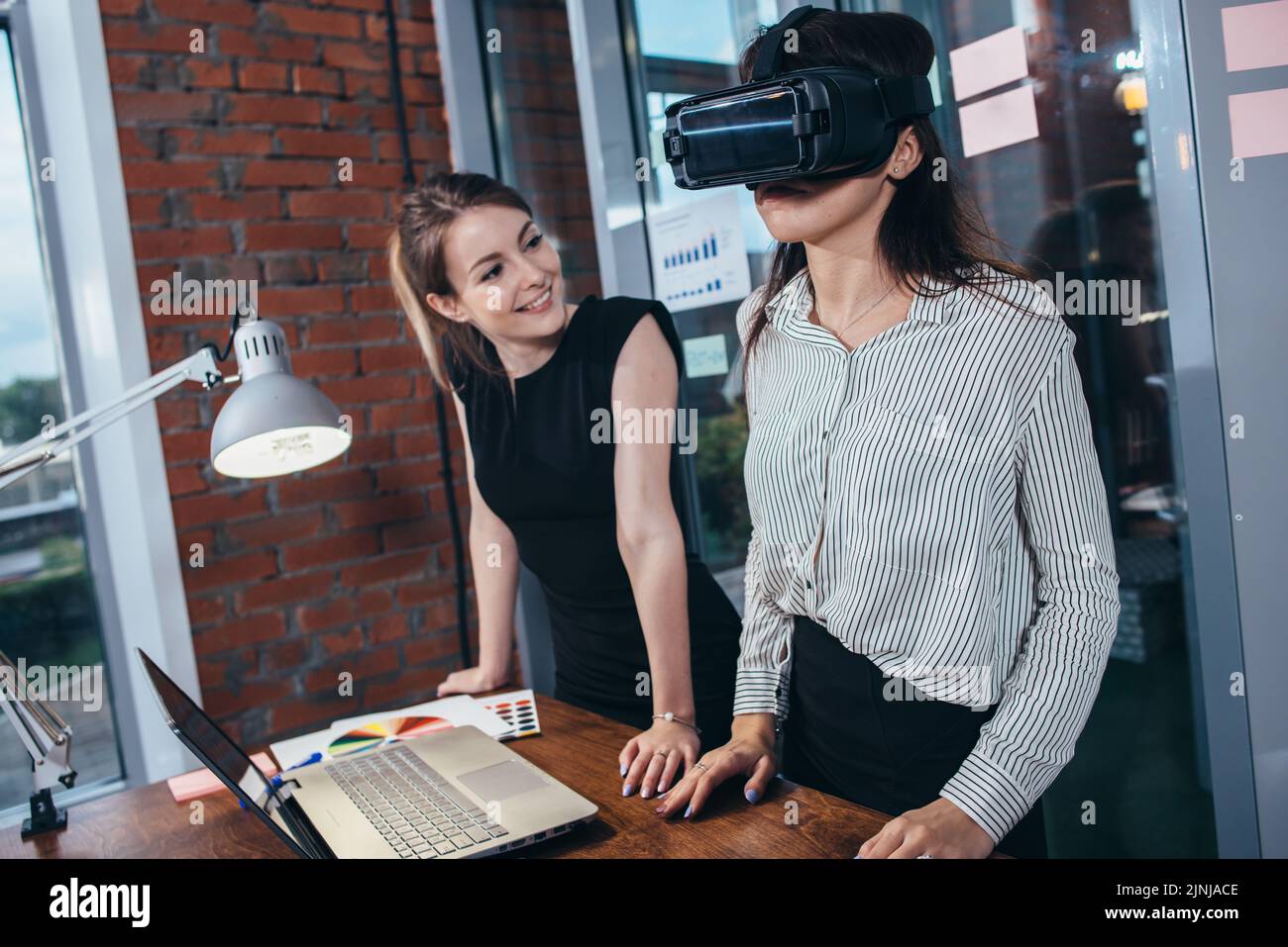 Two female students playing a 3d game in VR glasses having a break ...