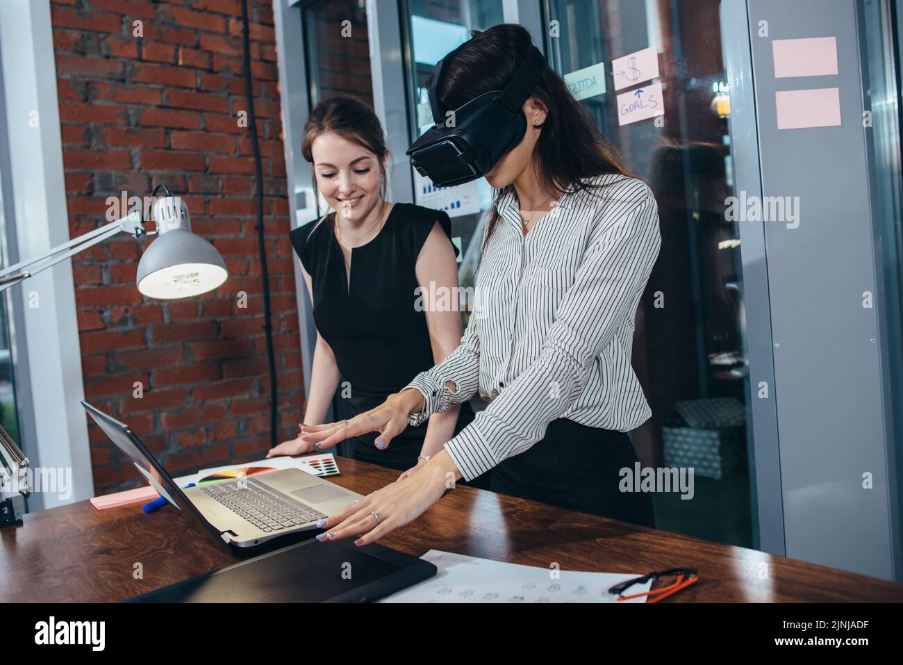 Two female students playing a 3d game in VR glasses having a break ...