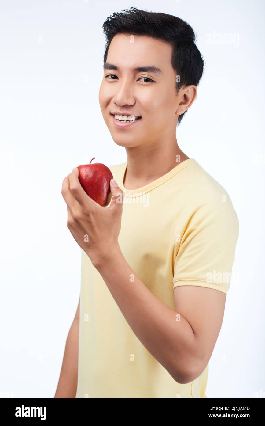 Portrait of happy Vietnamese young man eating an apple Stock Photo - Alamy