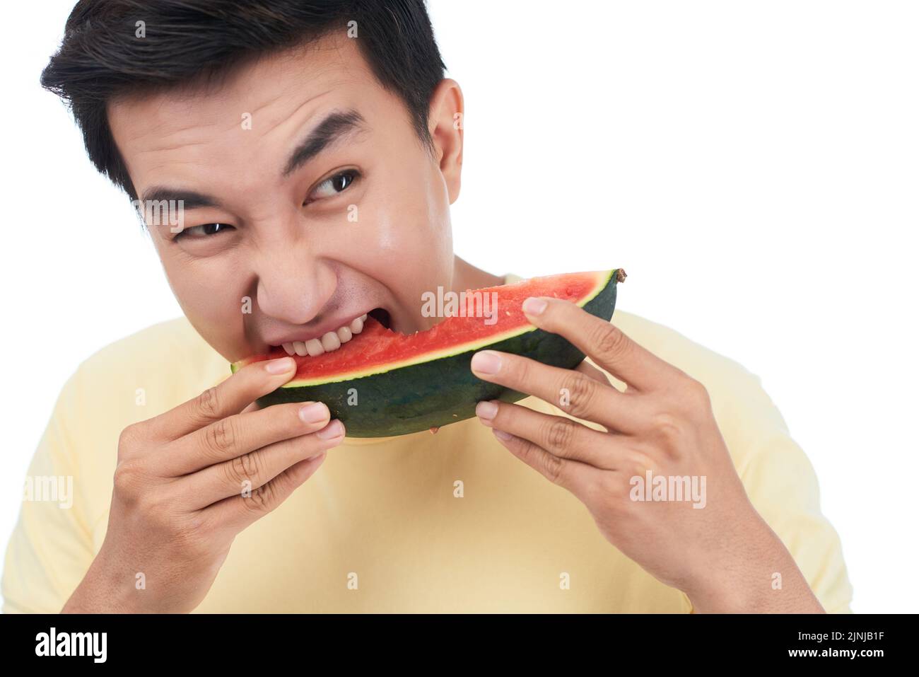 Hungry Vietnamese young man eating sweet watermelon Stock Photo - Alamy