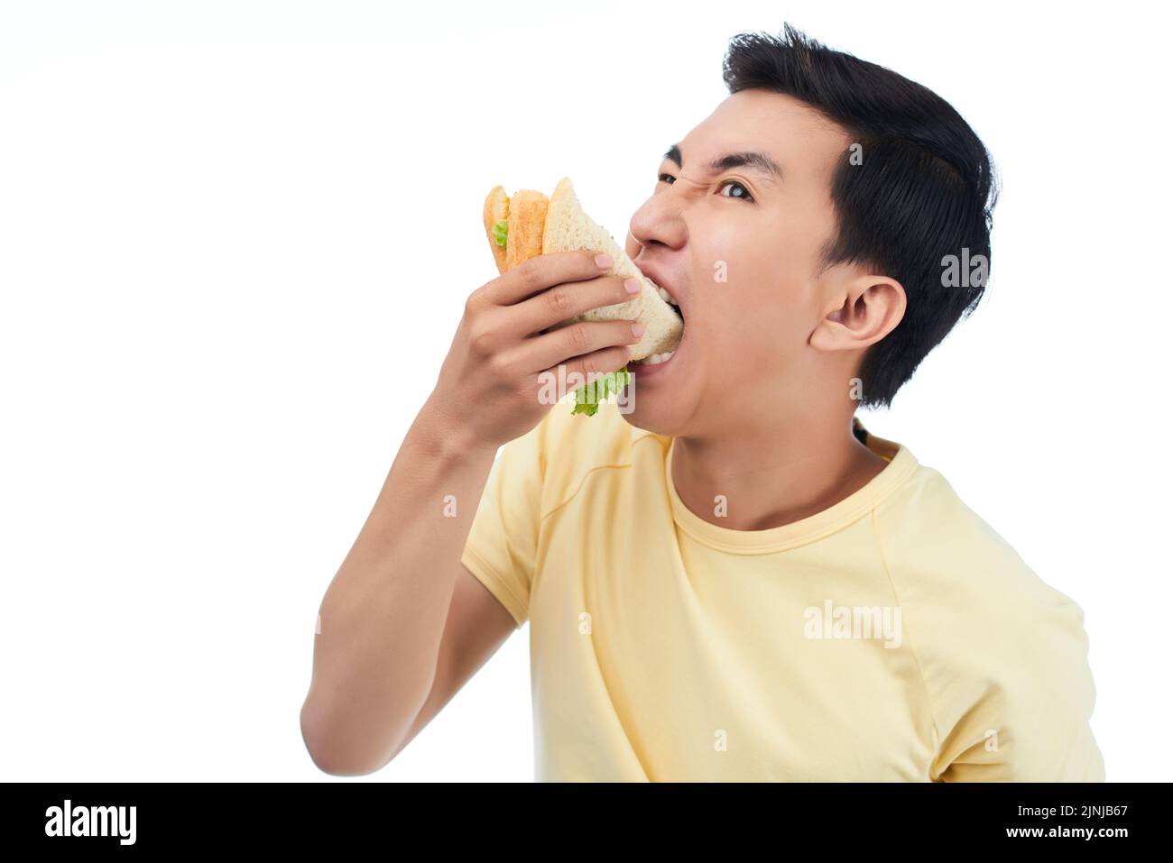 Young Vietnamese man devouring sandwich for lunch Stock Photo - Alamy