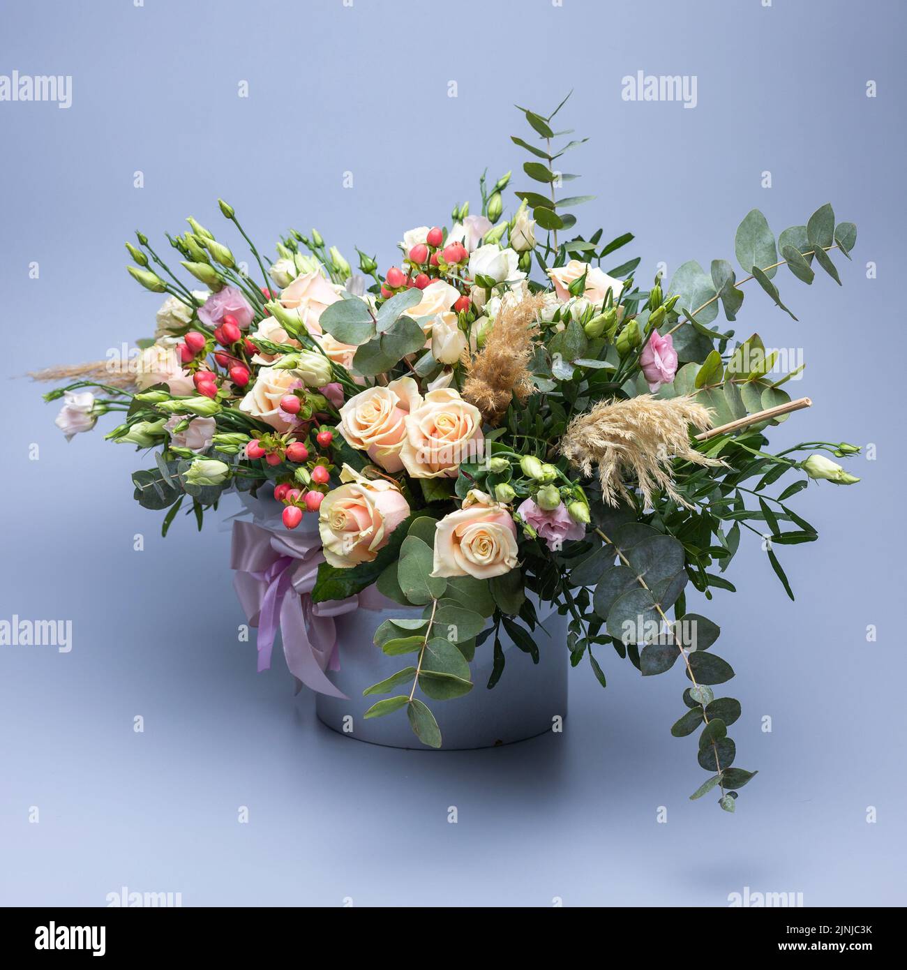 Festively packaged bouquet in pastel color composed of roses, other ...