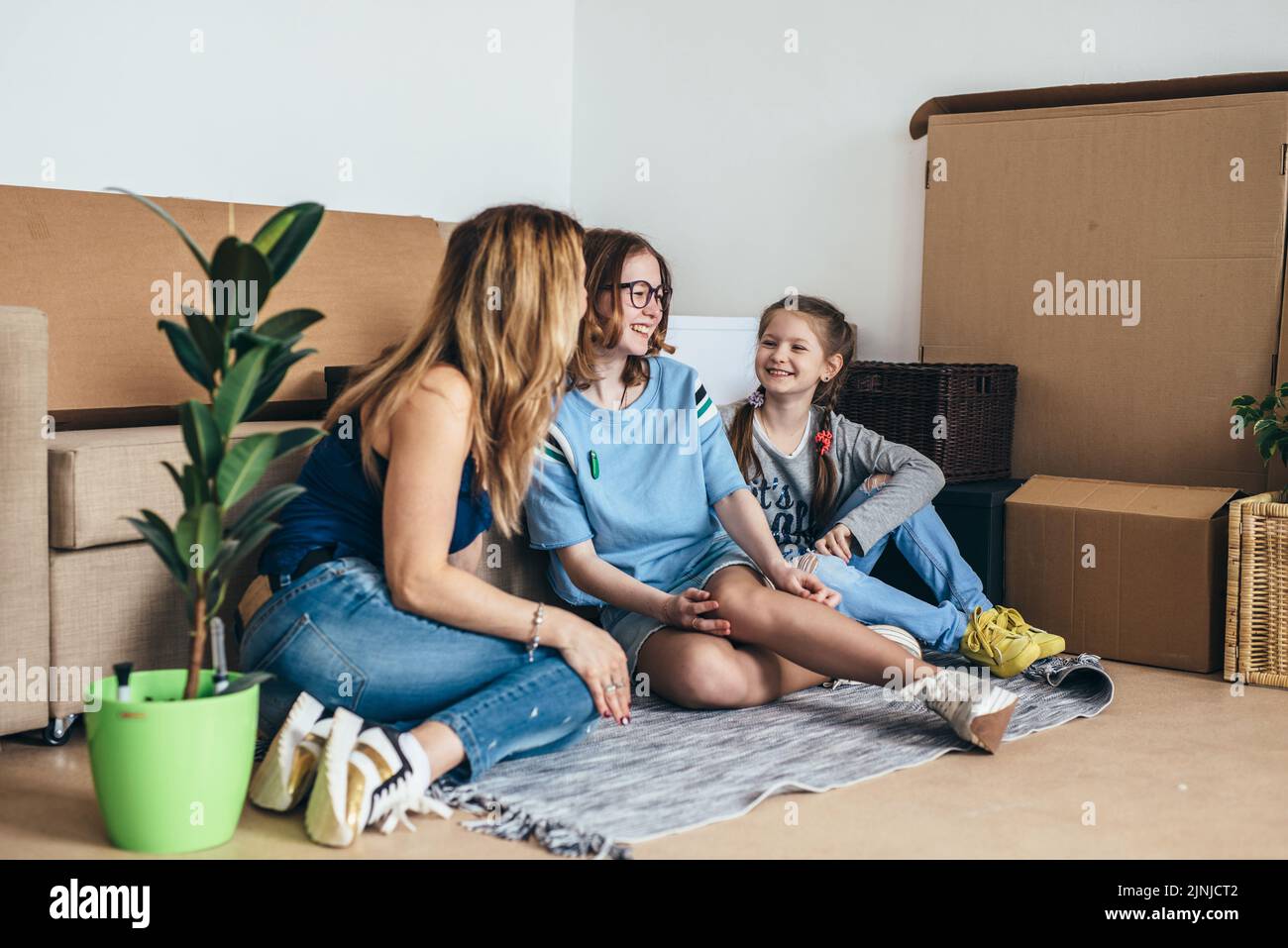 Family unpacking cardboard boxes at new home Stock Photo - Alamy