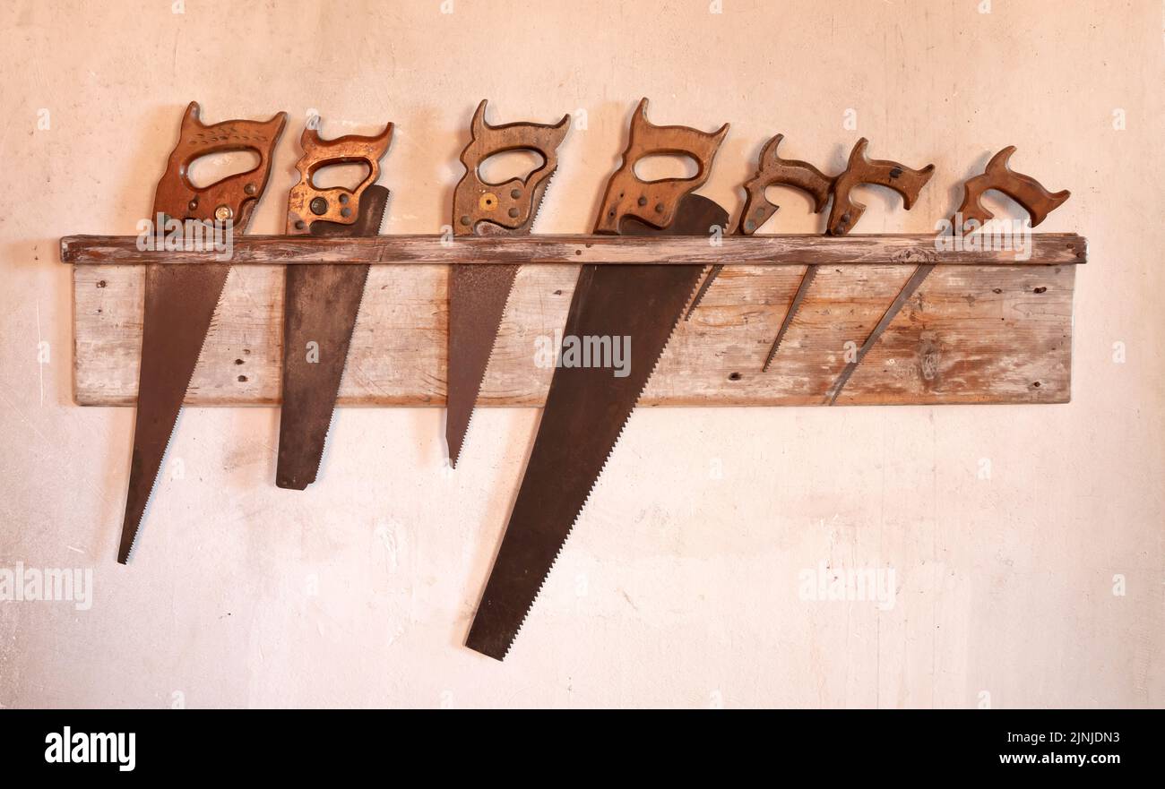 Carpenter vintage tool, row of saws in a rack Stock Photo - Alamy