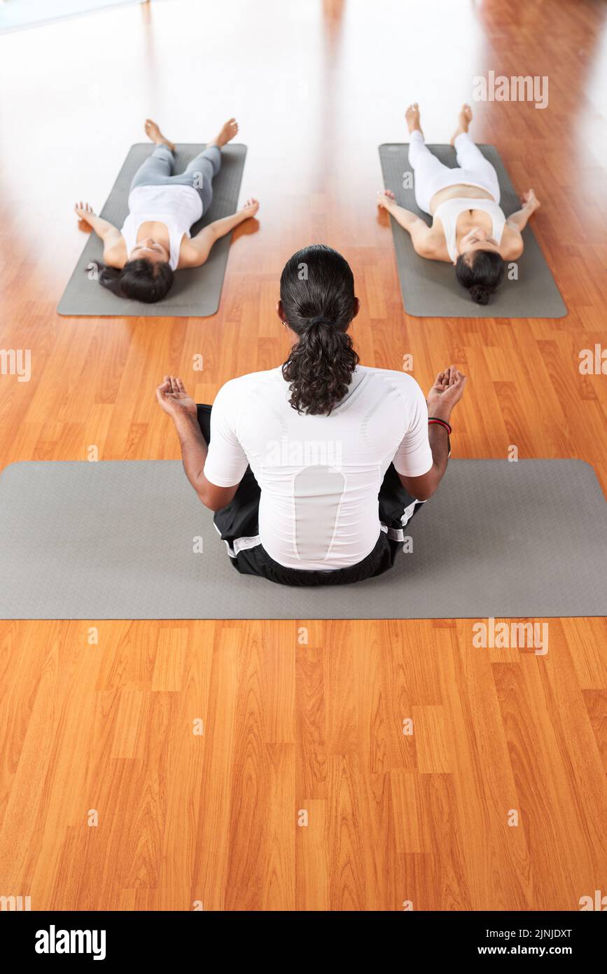 Rear view of yoga instructor practicing in class Stock Photo - Alamy