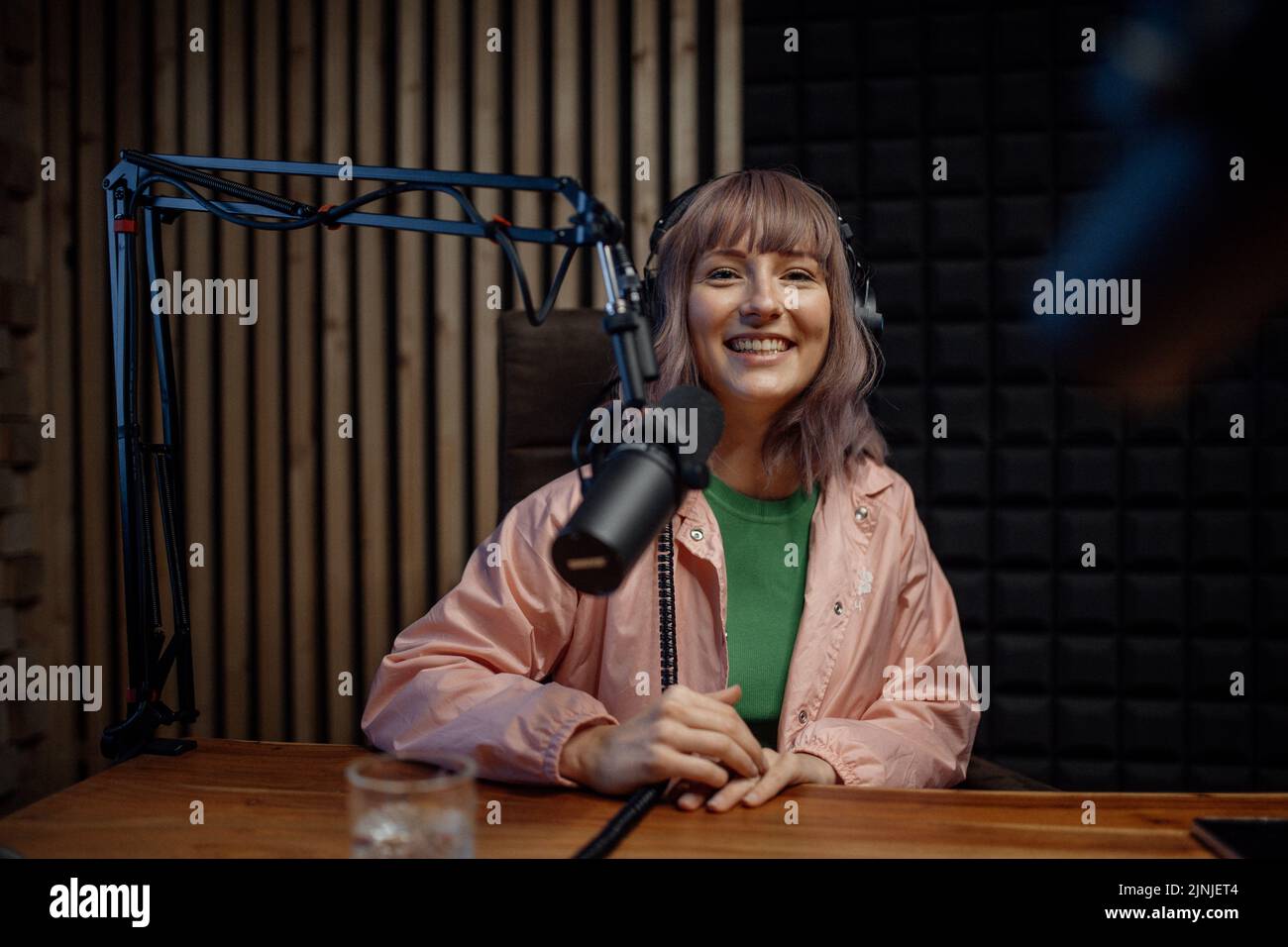 Portrait of female radio host speaking in microphone while moderating a ...