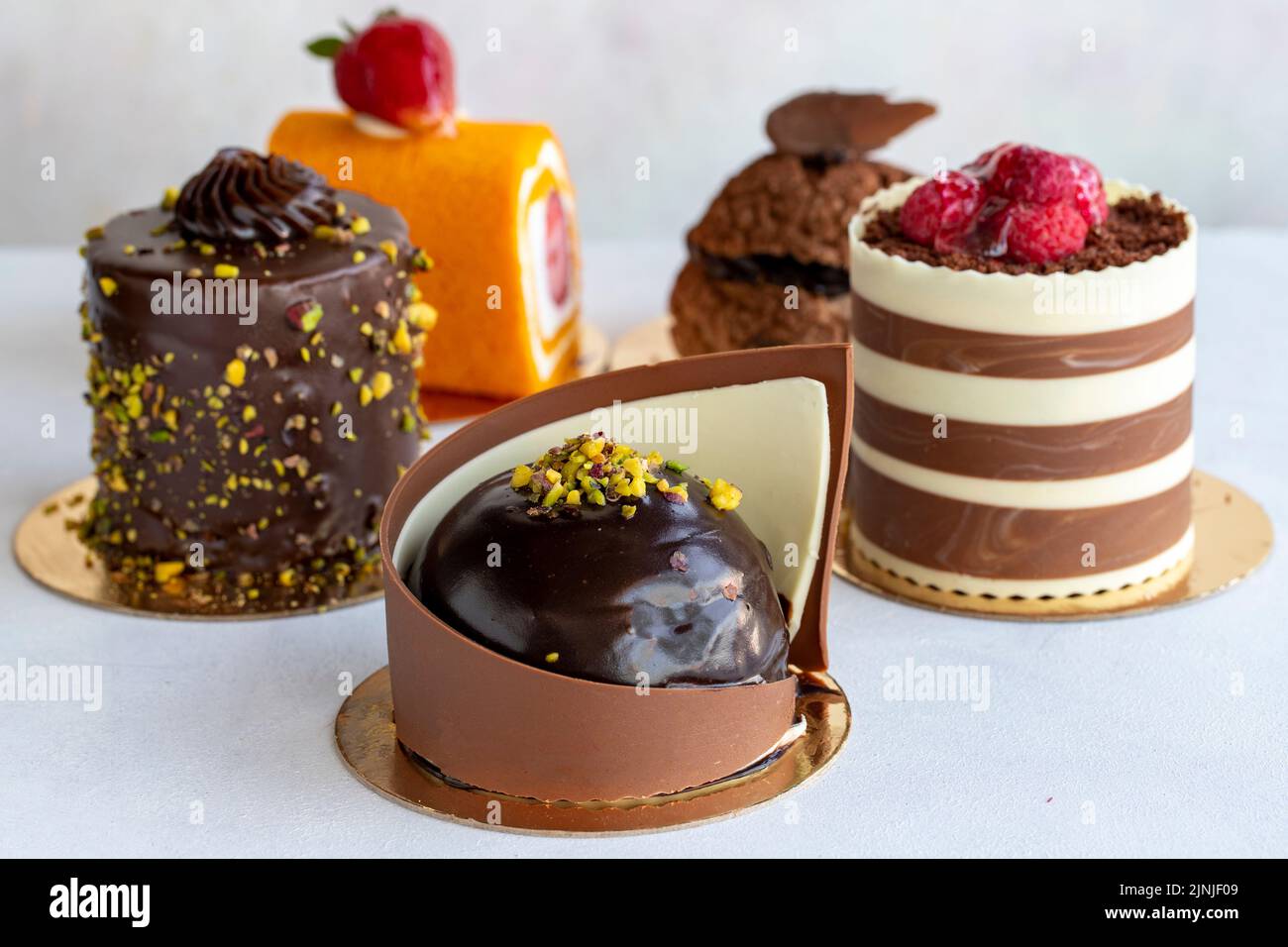 Types of cakes. Small sweet cakes on a white background. Bakery ...