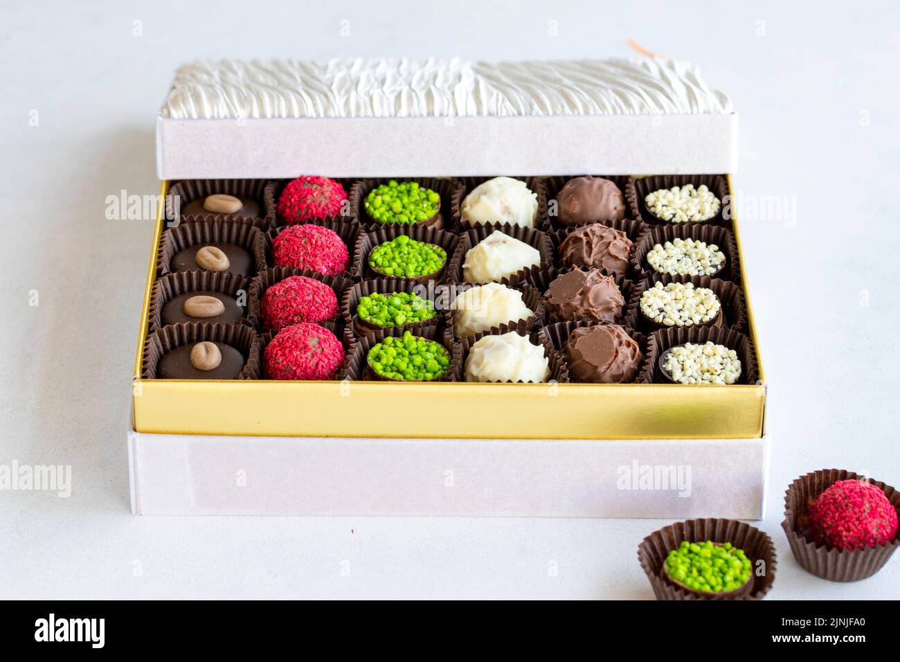 Packed chocolate. Assortment of packed truffle chocolates on a white ...