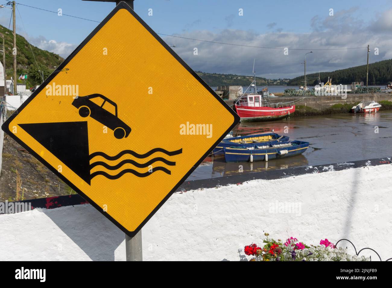 A closeup of a car falling into water warning sign near a dock Stock ...
