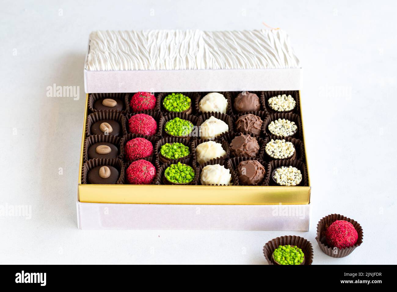 Packed chocolate. Assortment of packed truffle chocolates on a white ...