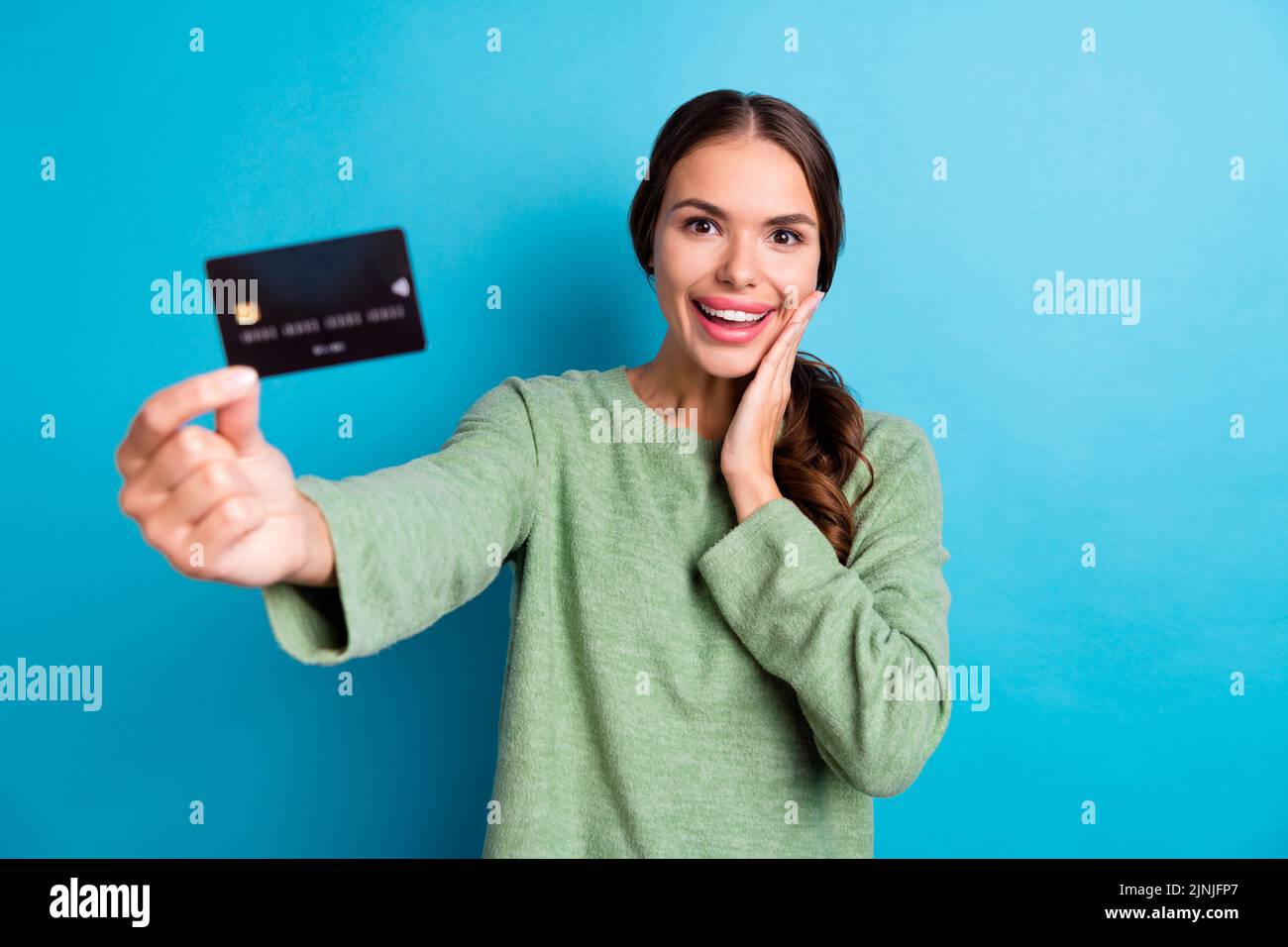 Photo of astonished girl hand touch cheek hold plastic debit card ...