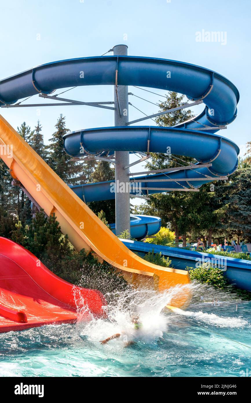 Water slide in aquapark. Splashing into the water Stock Photo - Alamy